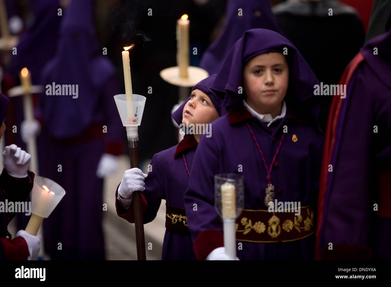 A boy looks at his candle's flame during an Easter Holy Week procession ...