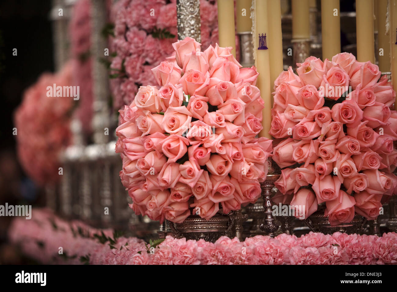 Flower arrangements made with pink roses decorate a throne during an ...