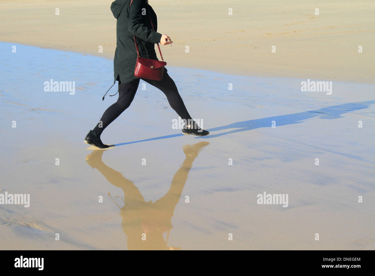 Woman walking on wet ocean sand beach hi-res stock photography and ...