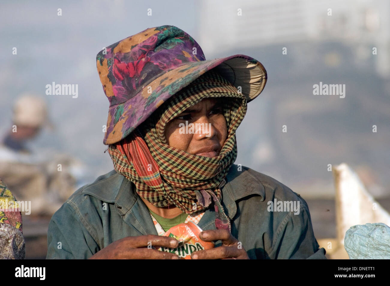 A woman scavenger who collects recyclable material is sitting in the ...