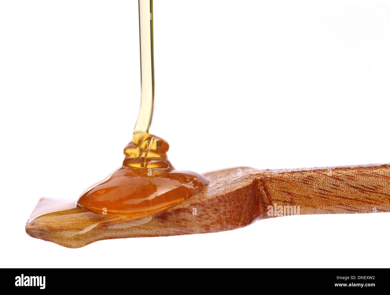 Dripping honey on wooden spoon over white background Stock Photo - Alamy