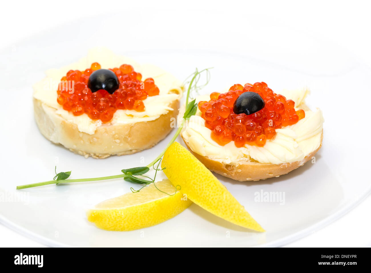canape with red caviar and lemon on white background Stock Photo - Alamy