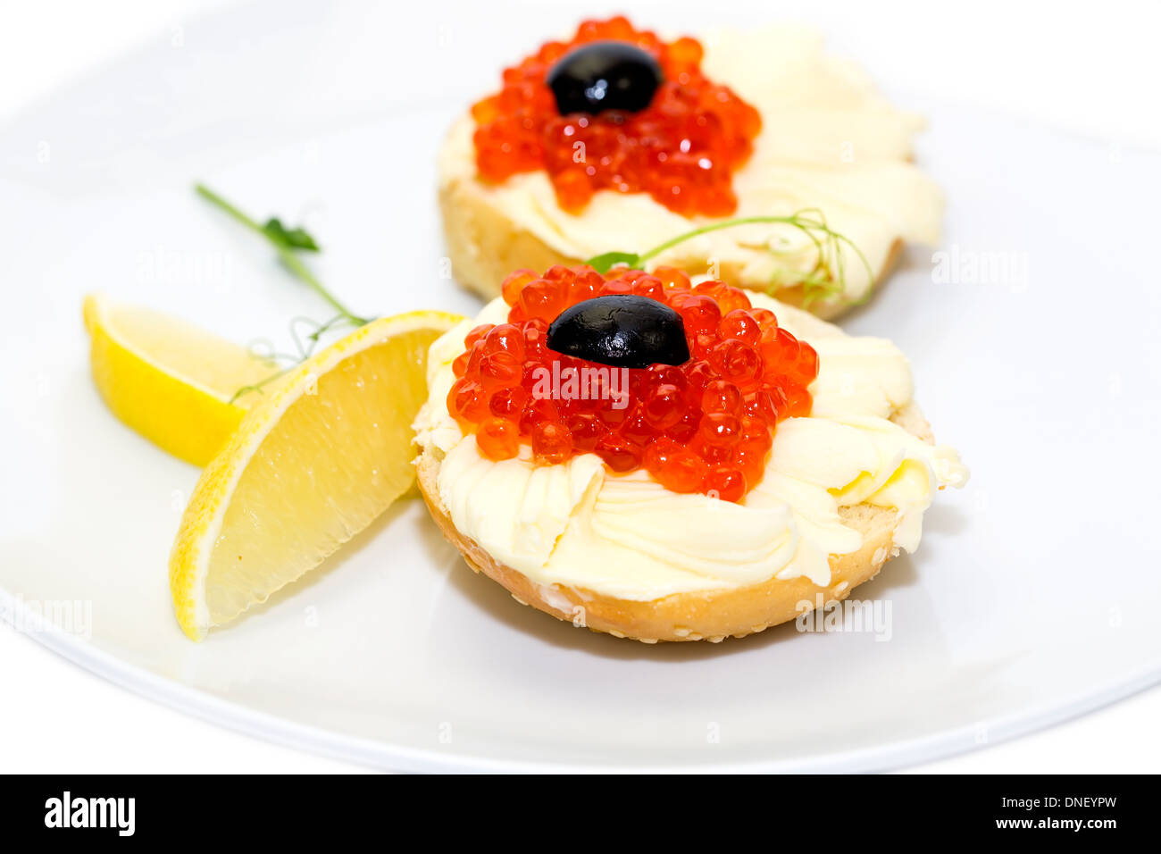 canape with red caviar and lemon on white background Stock Photo - Alamy