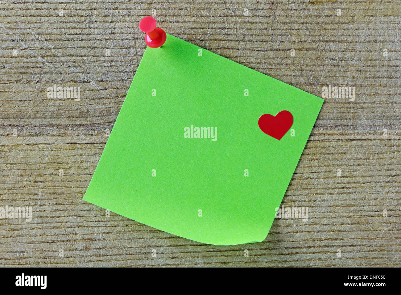 Green post it note on a wooden background with a heart symbol - ideal ...