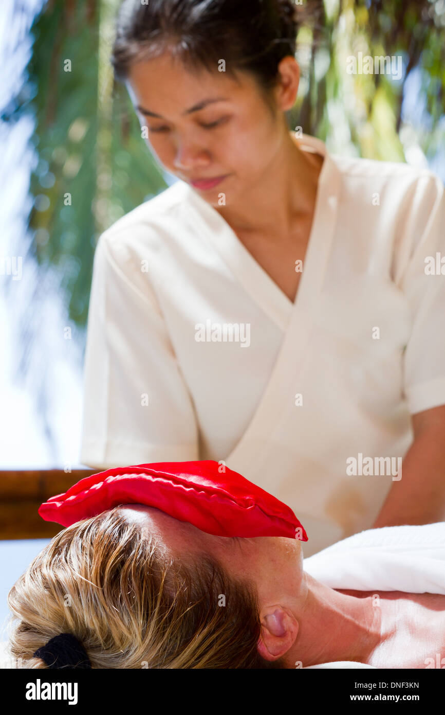 caucasian woman on a tropical vacation receiving a full body massage ...