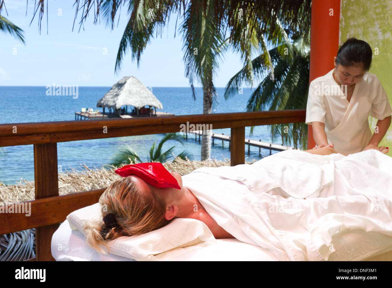 caucasian woman on a tropical vacation receiving a full body massage ...