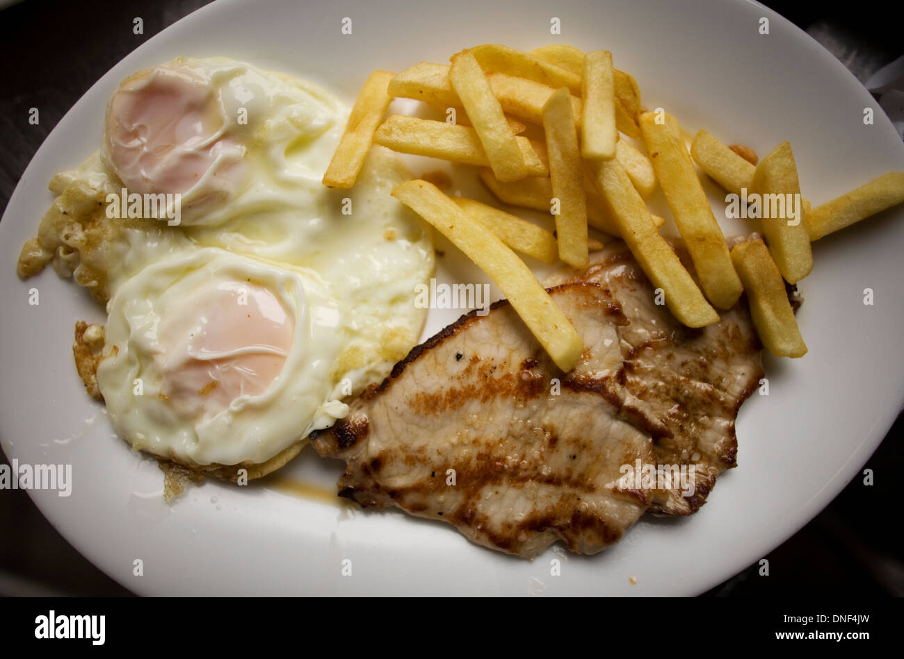 A combination plate or plato combinado with fried eggs, fried potatoes ...