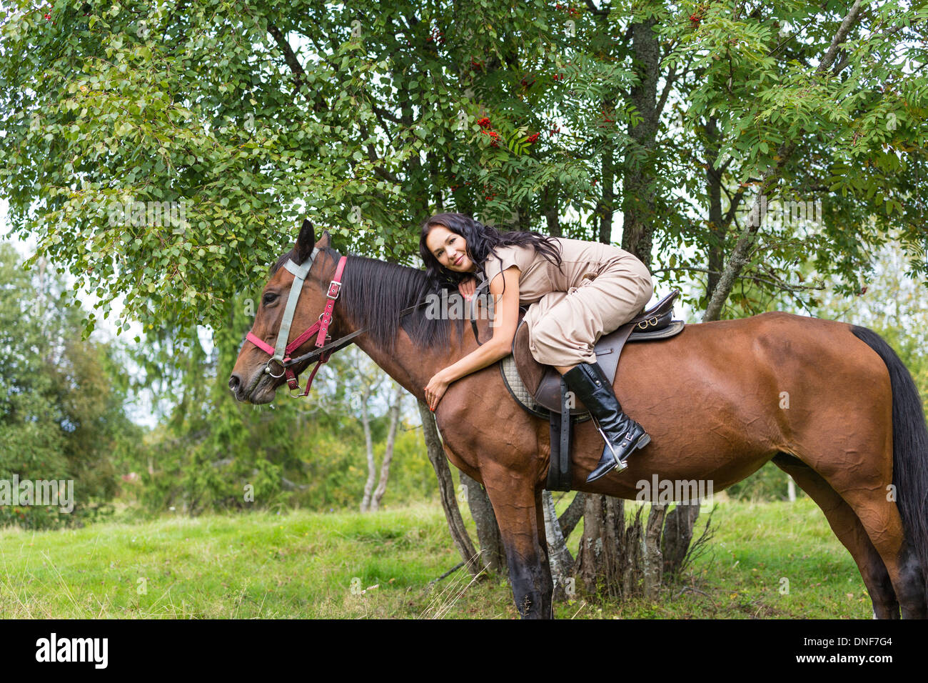 Elegant young woman riding horse Stock Photo - Alamy