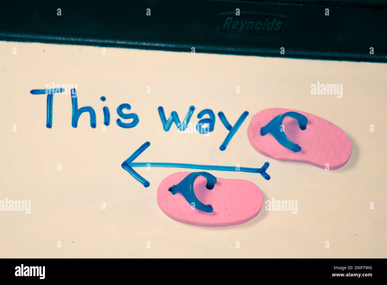 Miniature rubber slippers with wording This way, Concept Stock Photo ...