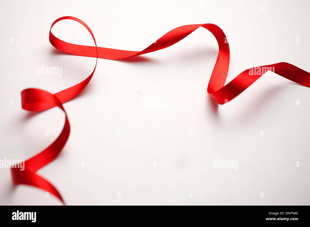 Red ribbon curling on white background Stock Photo - Alamy