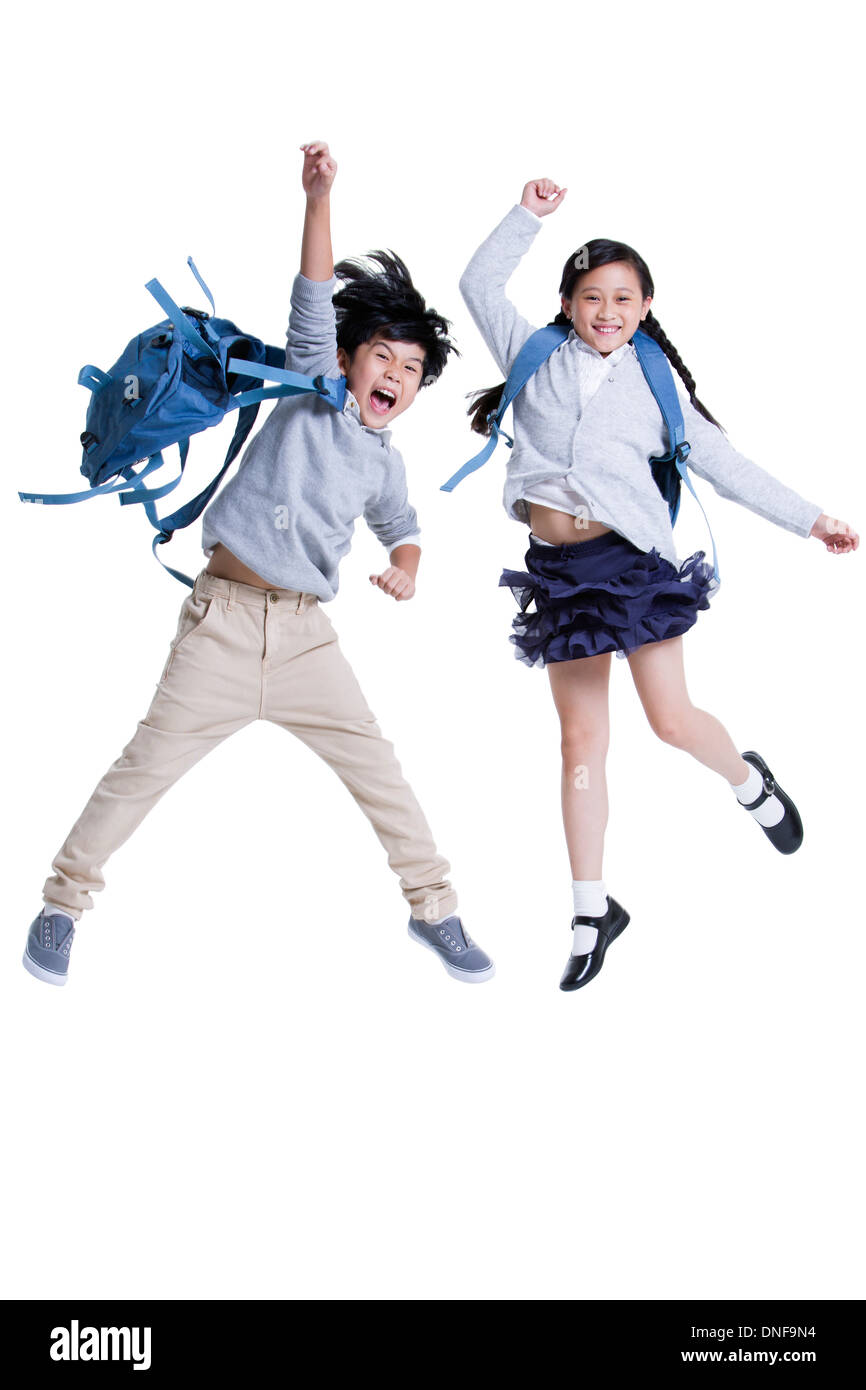 Excited schoolboy and schoolgirl jumping Stock Photo - Alamy