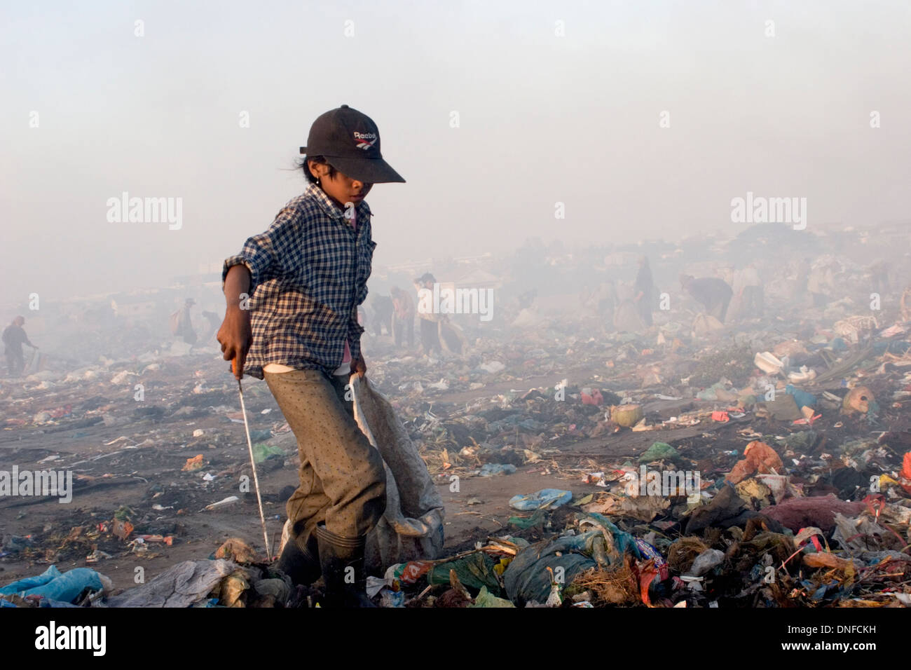 A young child laborer girl is collecting recyclable material at the ...