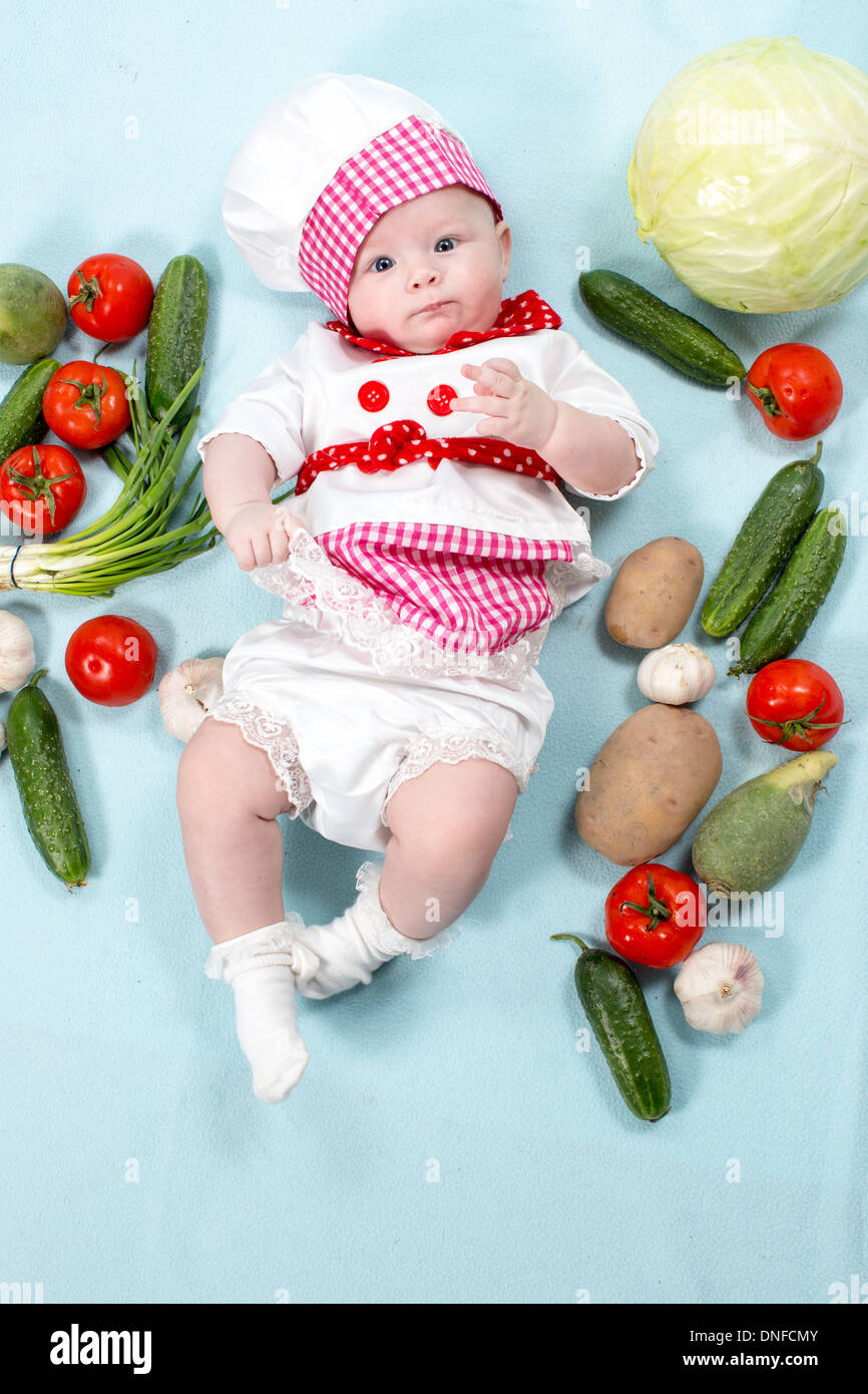 Baby cook girl wearing chef hat with fresh vegetables. Use it for a ...