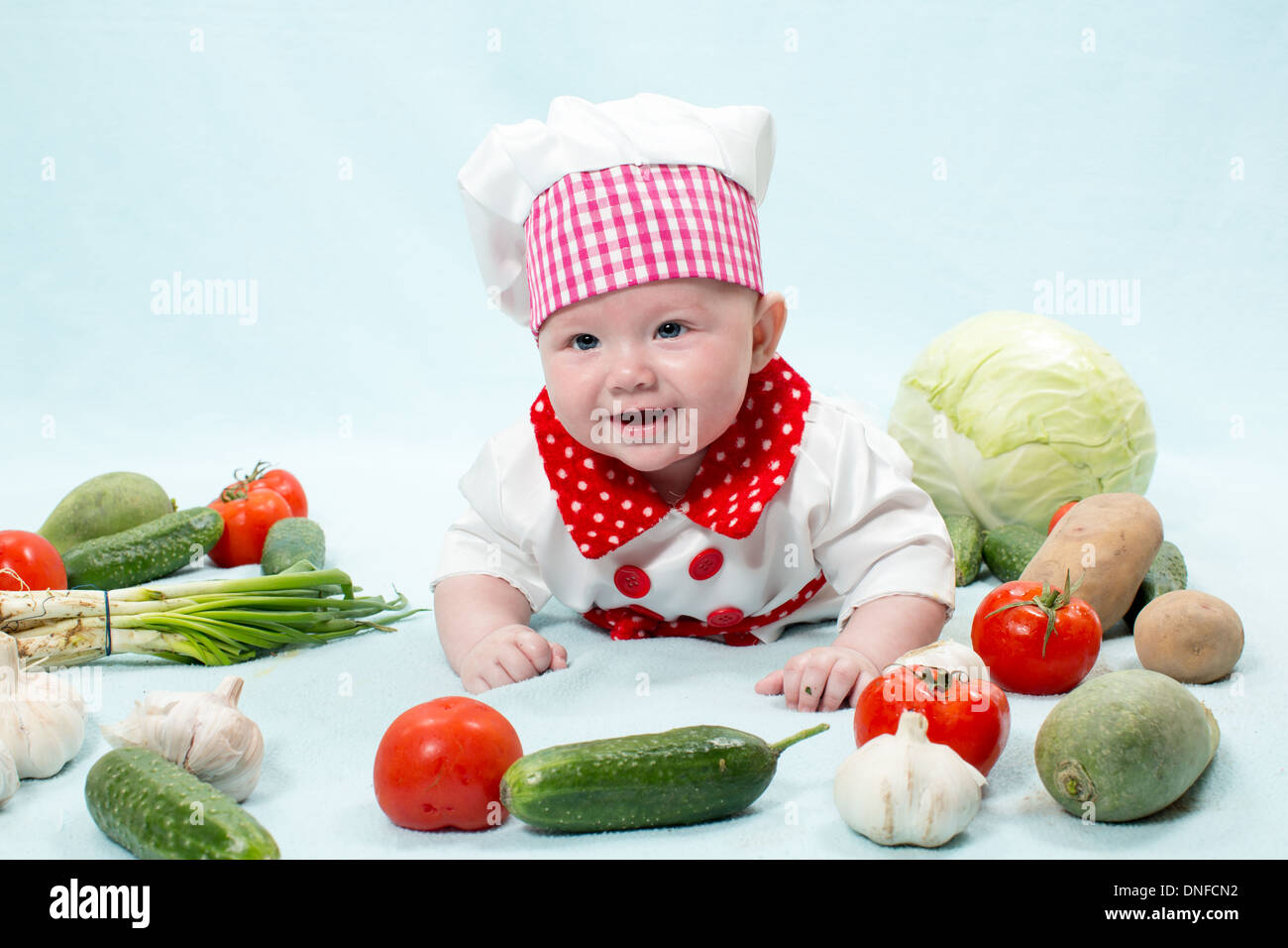Baby cook girl wearing chef hat with fresh vegetables. Use it for a ...