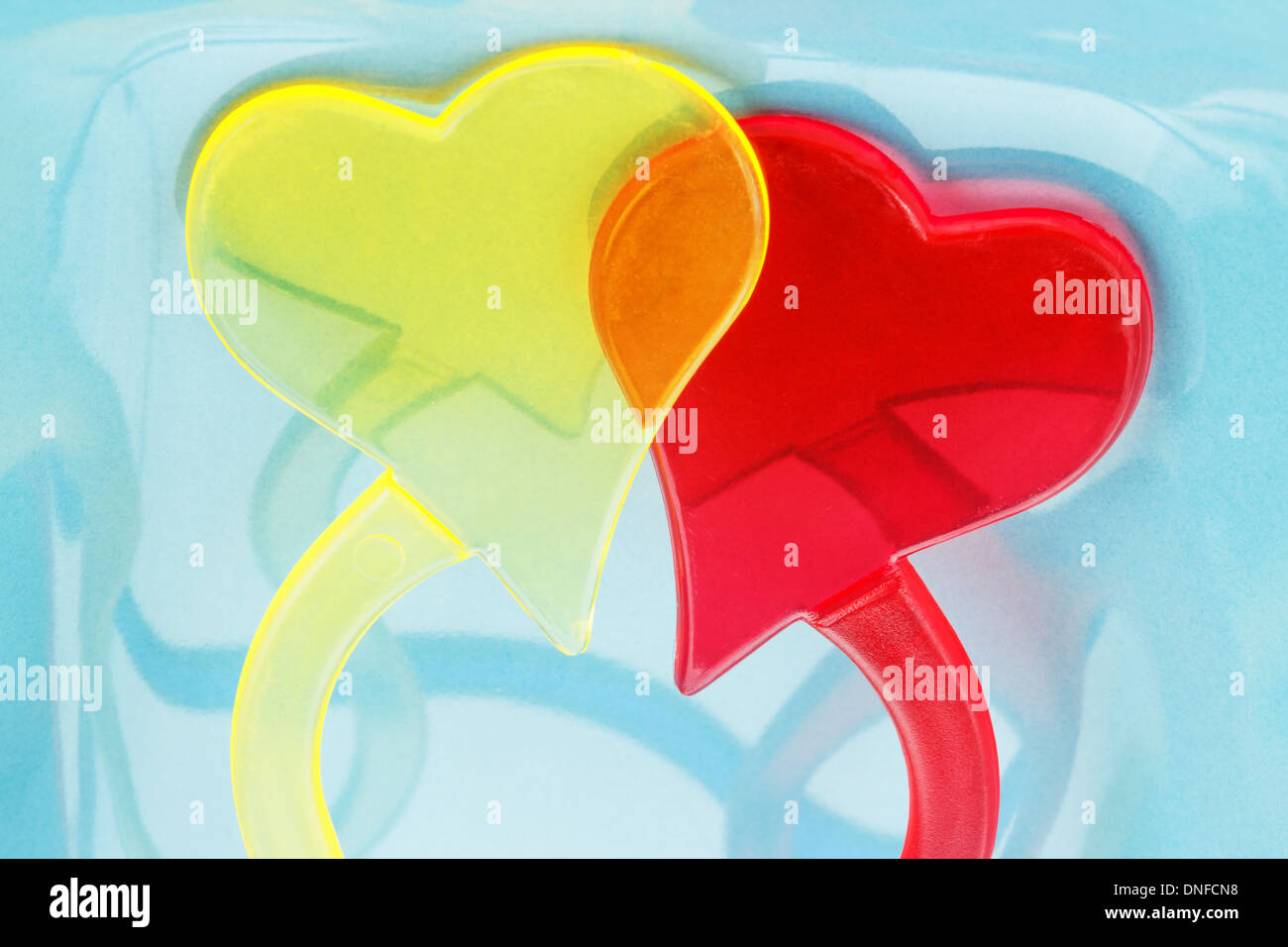 two plastic hearts on a blue reflecting surface Stock Photo - Alamy