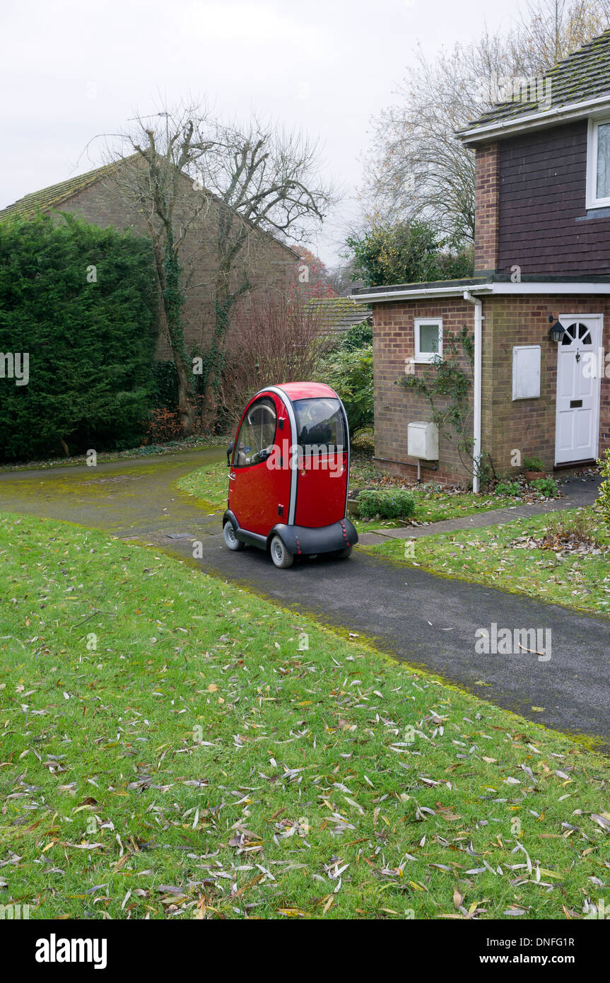 Stationary red mobility vehicle for the disabled parked on a footpath ...