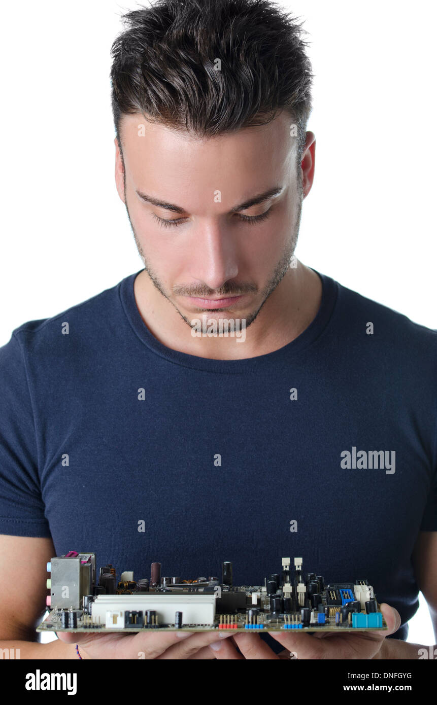 Confused, puzzled computer technician, a handsome young man, looking at ...