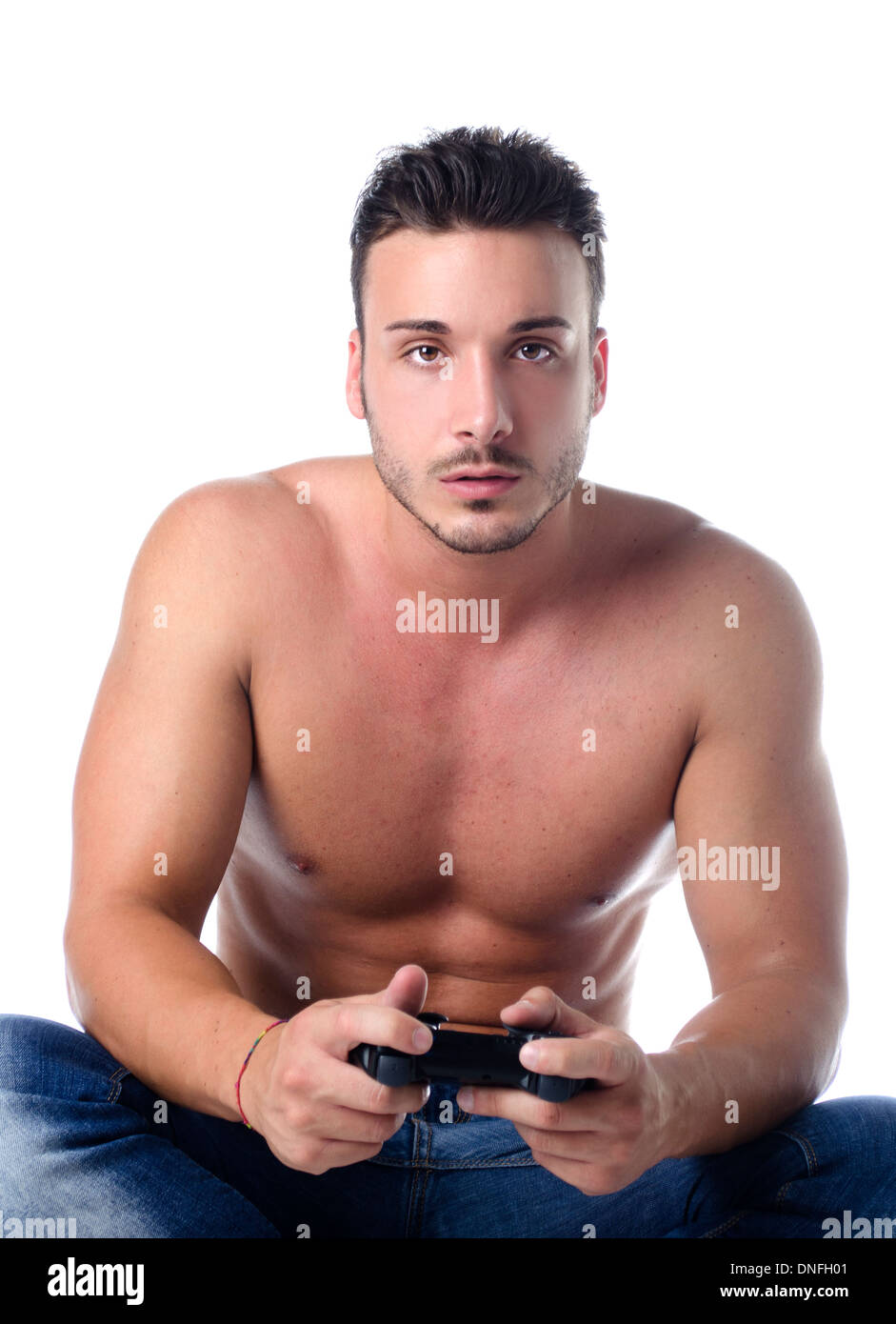 Handsome young man shirtless playing console videogames with joypad in ...