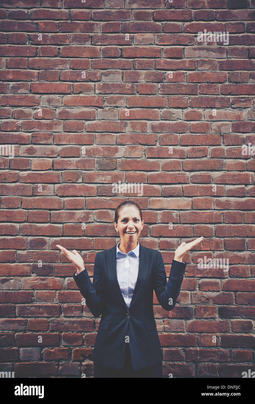 Image of impatient businesswoman with open palms on background of brick ...