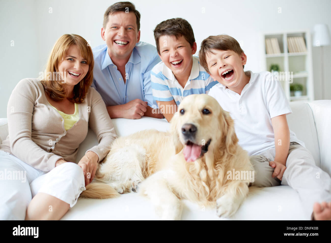 Portrait of happy family with their pet having good time at home Stock ...