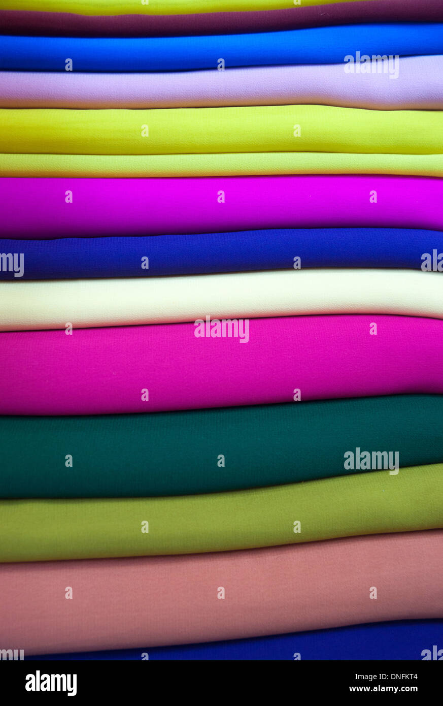 Brightly colored fabric folded and stacked Stock Photo - Alamy