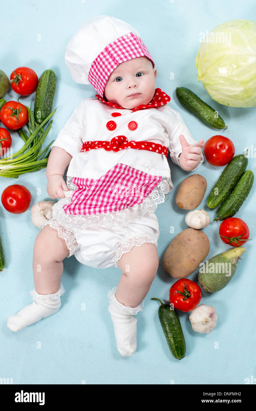 Baby cook girl wearing chef hat with fresh vegetables. Use it for a ...