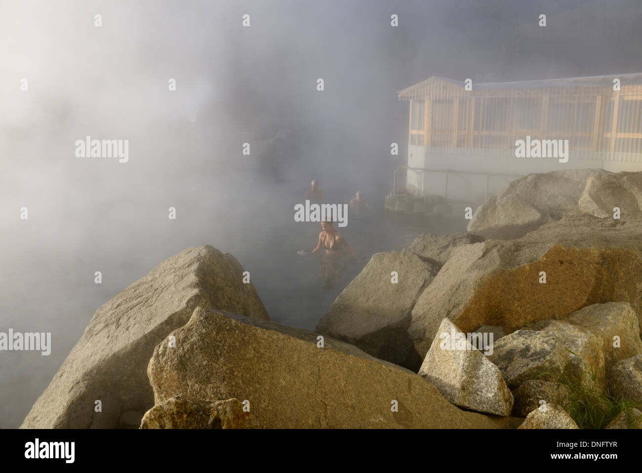Tourists entering the hot outdoor pool with steam rising off of the ...