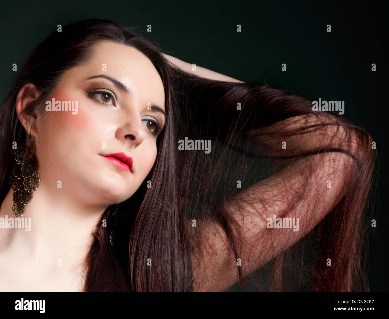 Portrait young woman straight long dark hair make up posing in studio ...