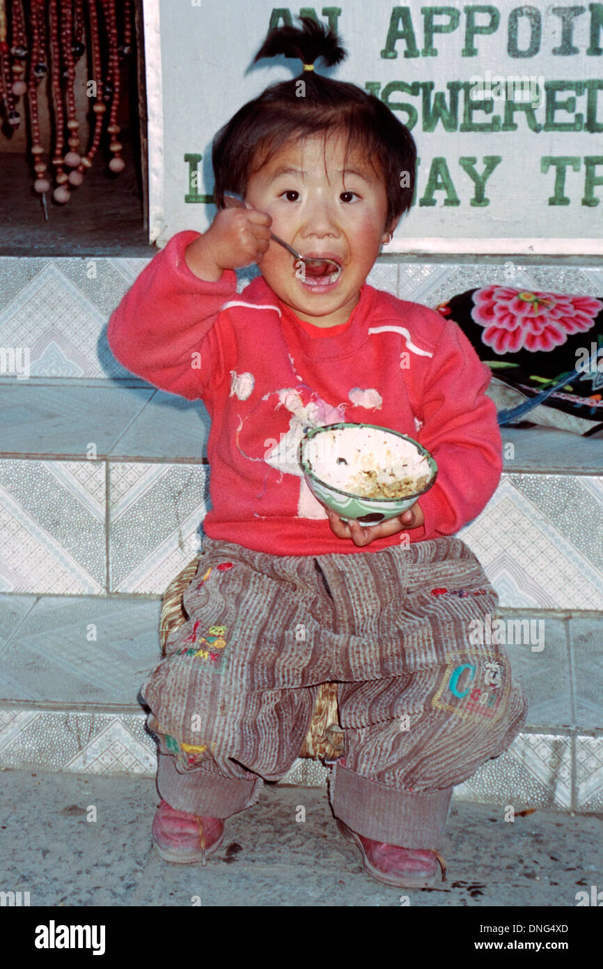 young child eating from a rice bowl in china Stock Photo - Alamy