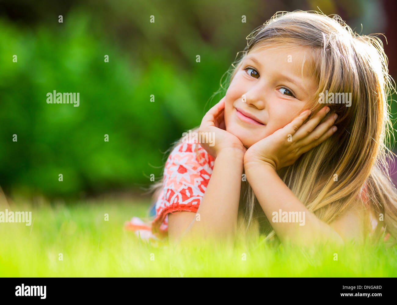 Cute happy little girl smiling outside on grass Stock Photo - Alamy