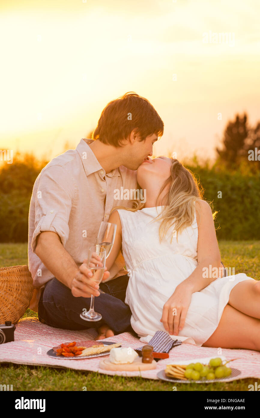 Attractive couple kissing on romantic sunset picnic Stock Photo - Alamy