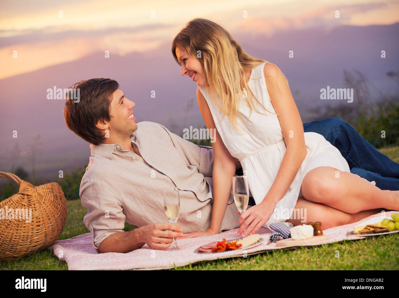 Attractive couple on romantic sunset picnic in countryside Stock Photo - Alamy