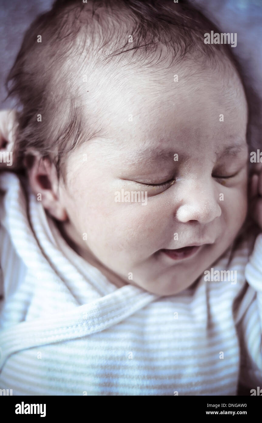 new born baby curled up sleeping on a blanket, multiple expressions ...