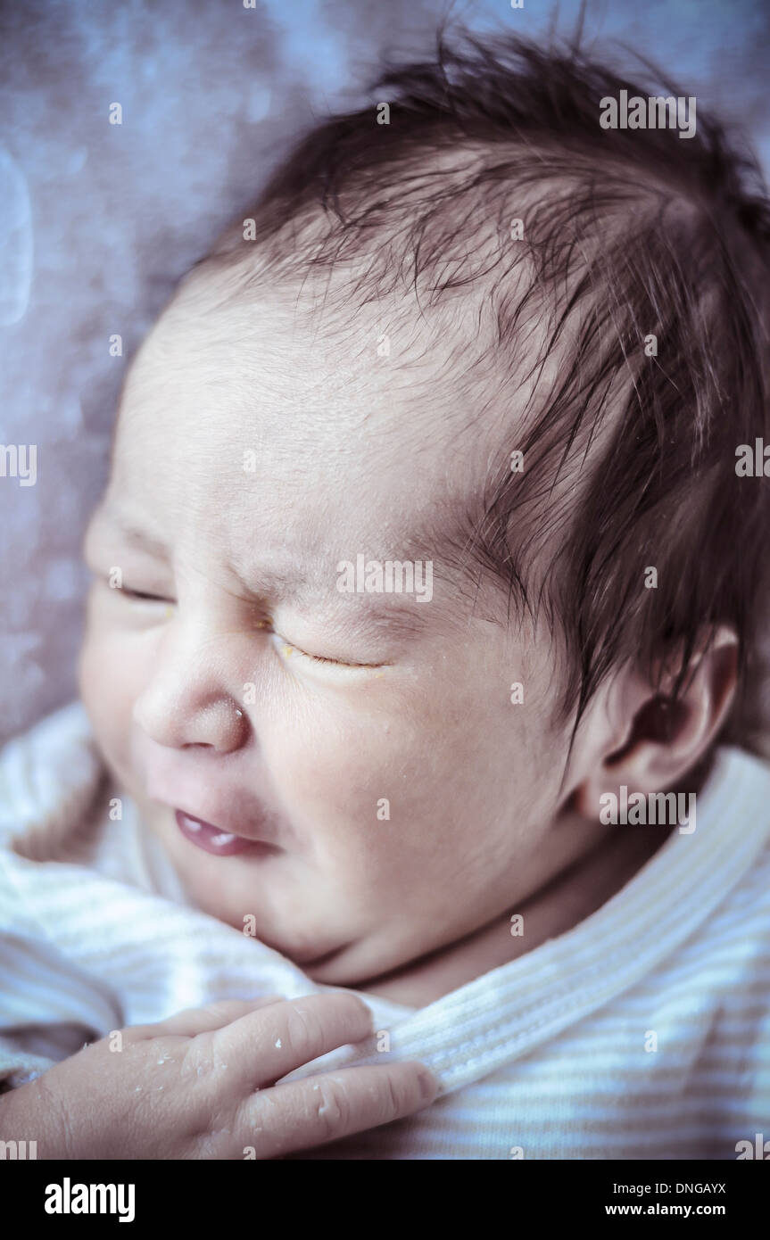 new born baby curled up sleeping on a blanket, multiple expressions ...