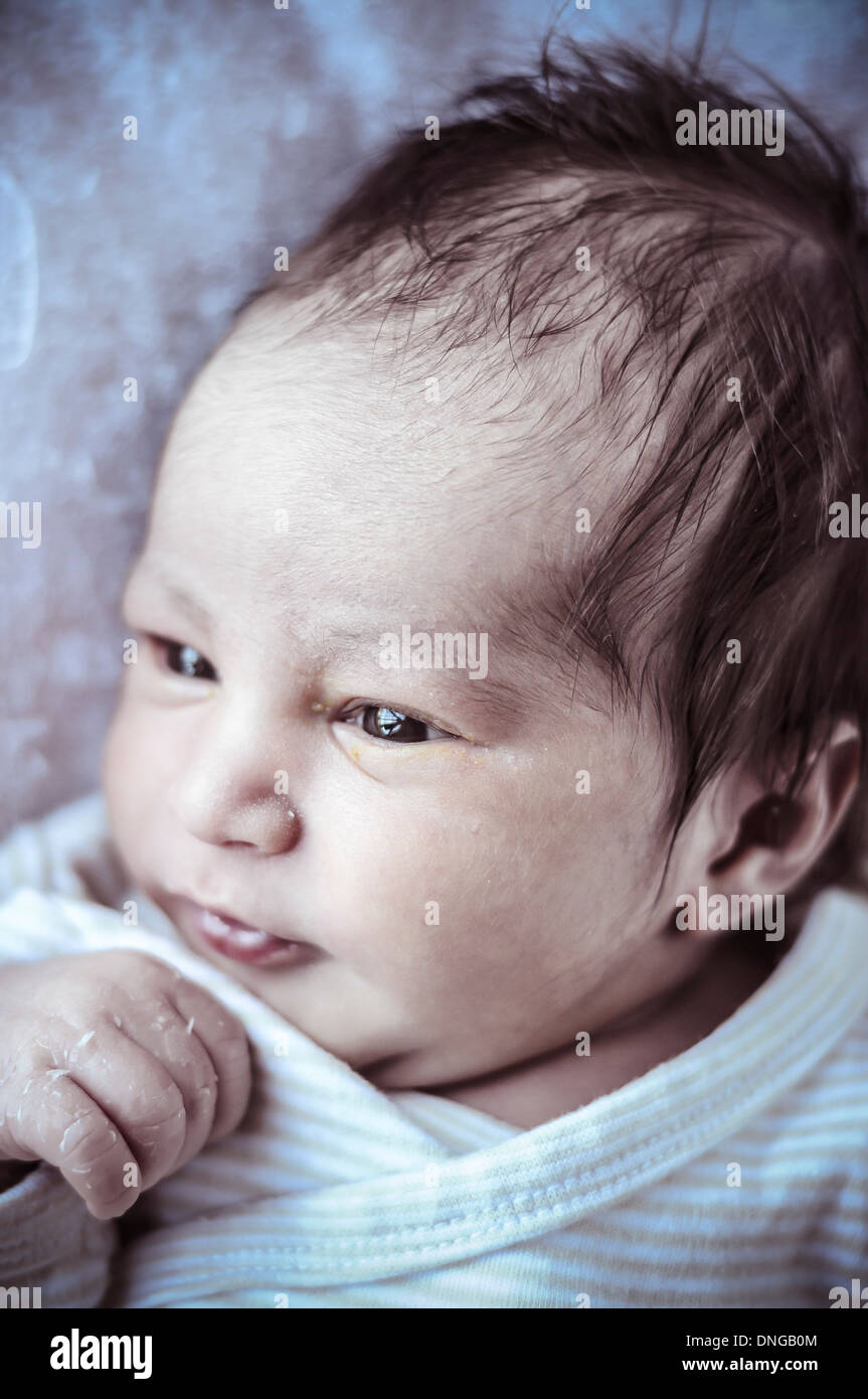 new born baby curled up sleeping on a blanket, multiple expressions ...