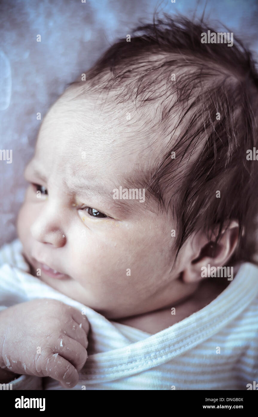 new born baby curled up sleeping on a blanket, multiple expressions ...