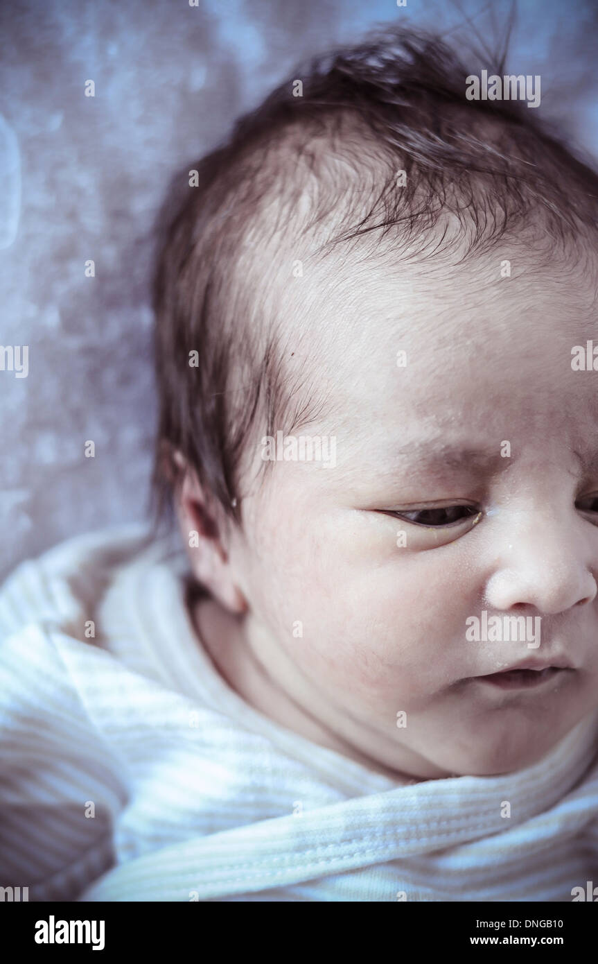 new born baby curled up sleeping on a blanket, multiple expressions ...