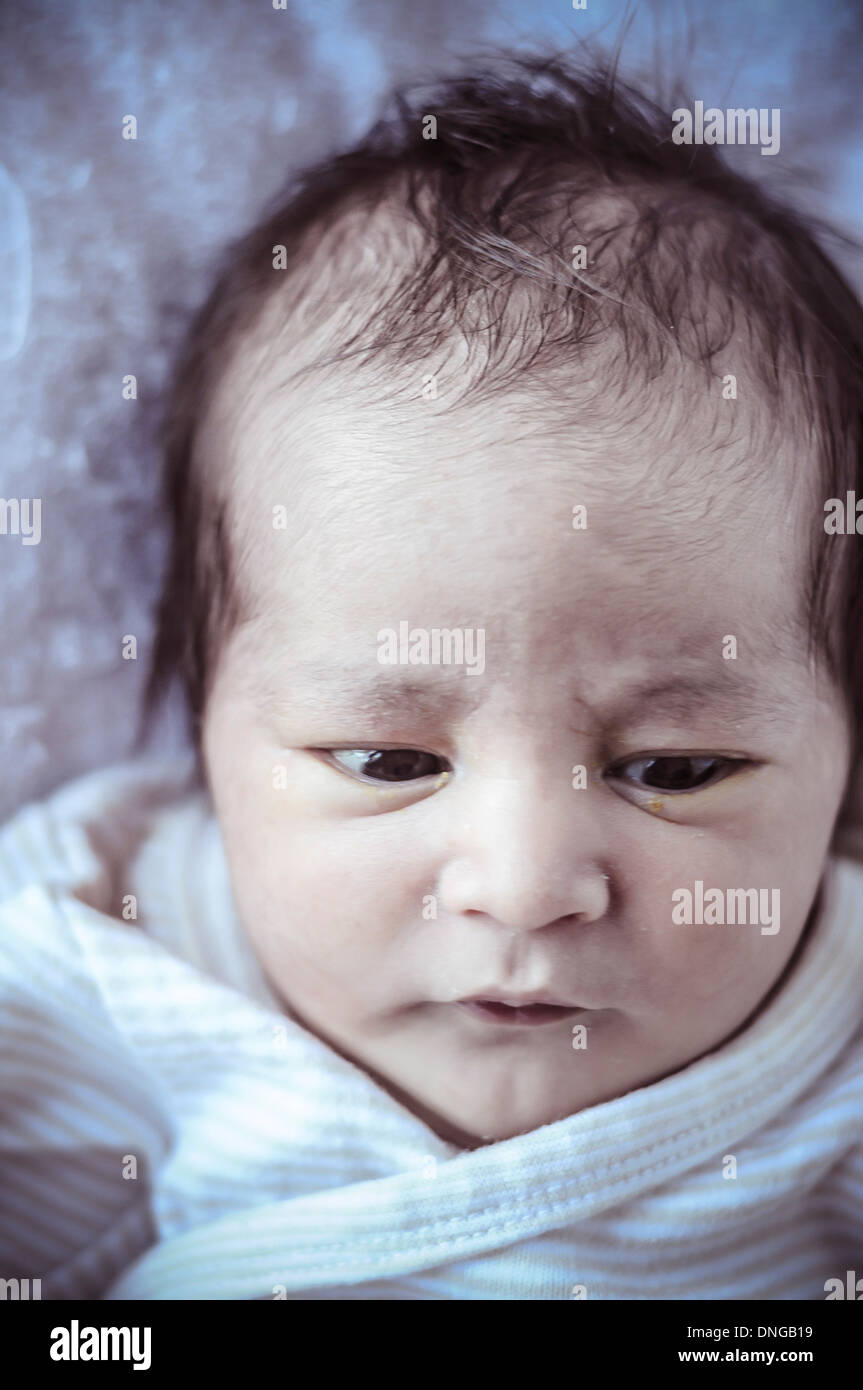 new born baby curled up sleeping on a blanket, multiple expressions ...