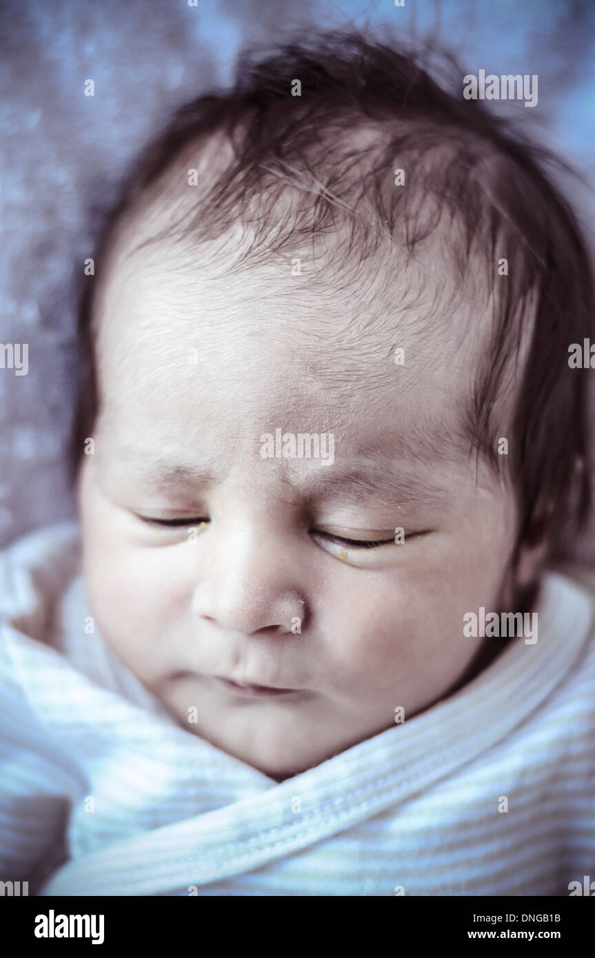 new born baby curled up sleeping on a blanket, multiple expressions ...