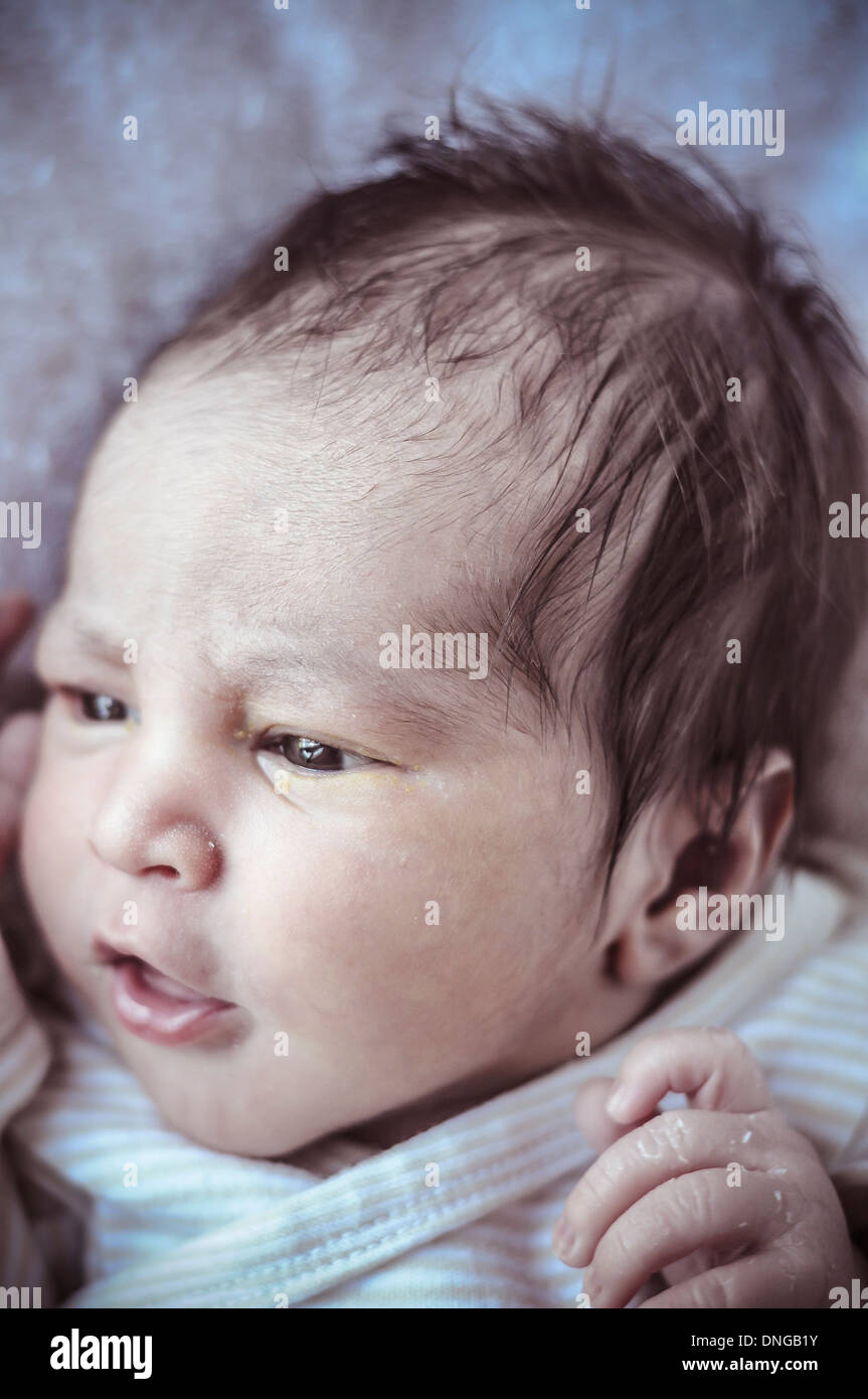 new born baby curled up sleeping on a blanket, multiple expressions ...
