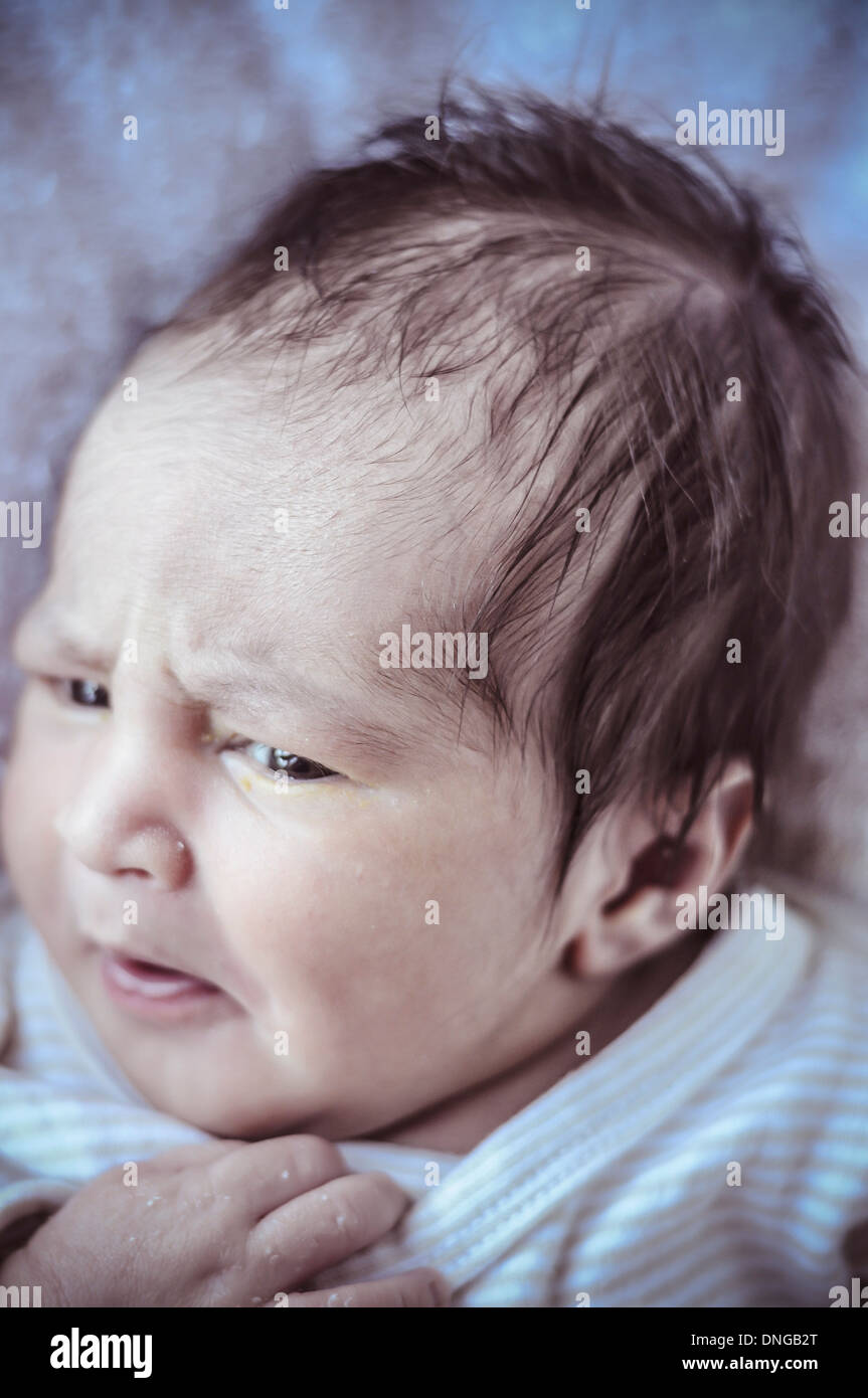 new born baby curled up sleeping on a blanket, multiple expressions ...