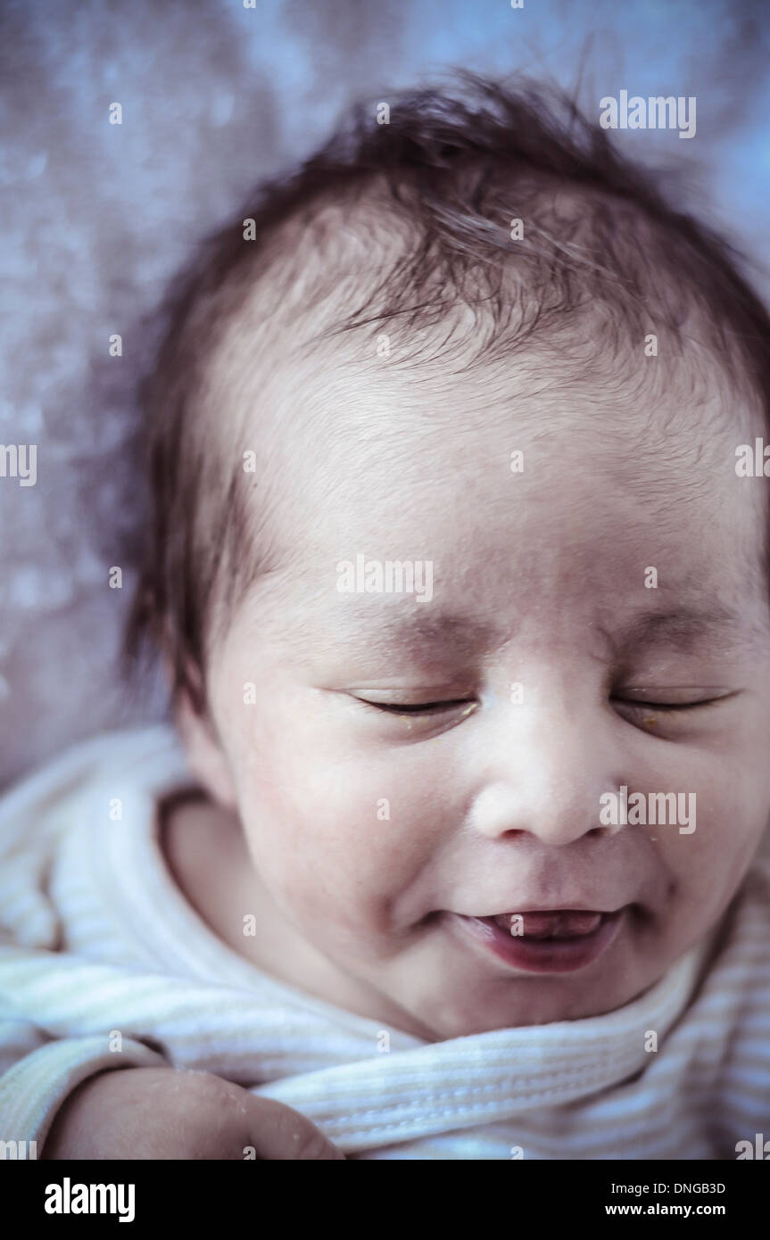 new born baby curled up sleeping on a blanket, multiple expressions ...
