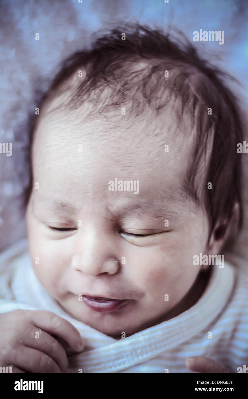 new born baby curled up sleeping on a blanket, multiple expressions ...