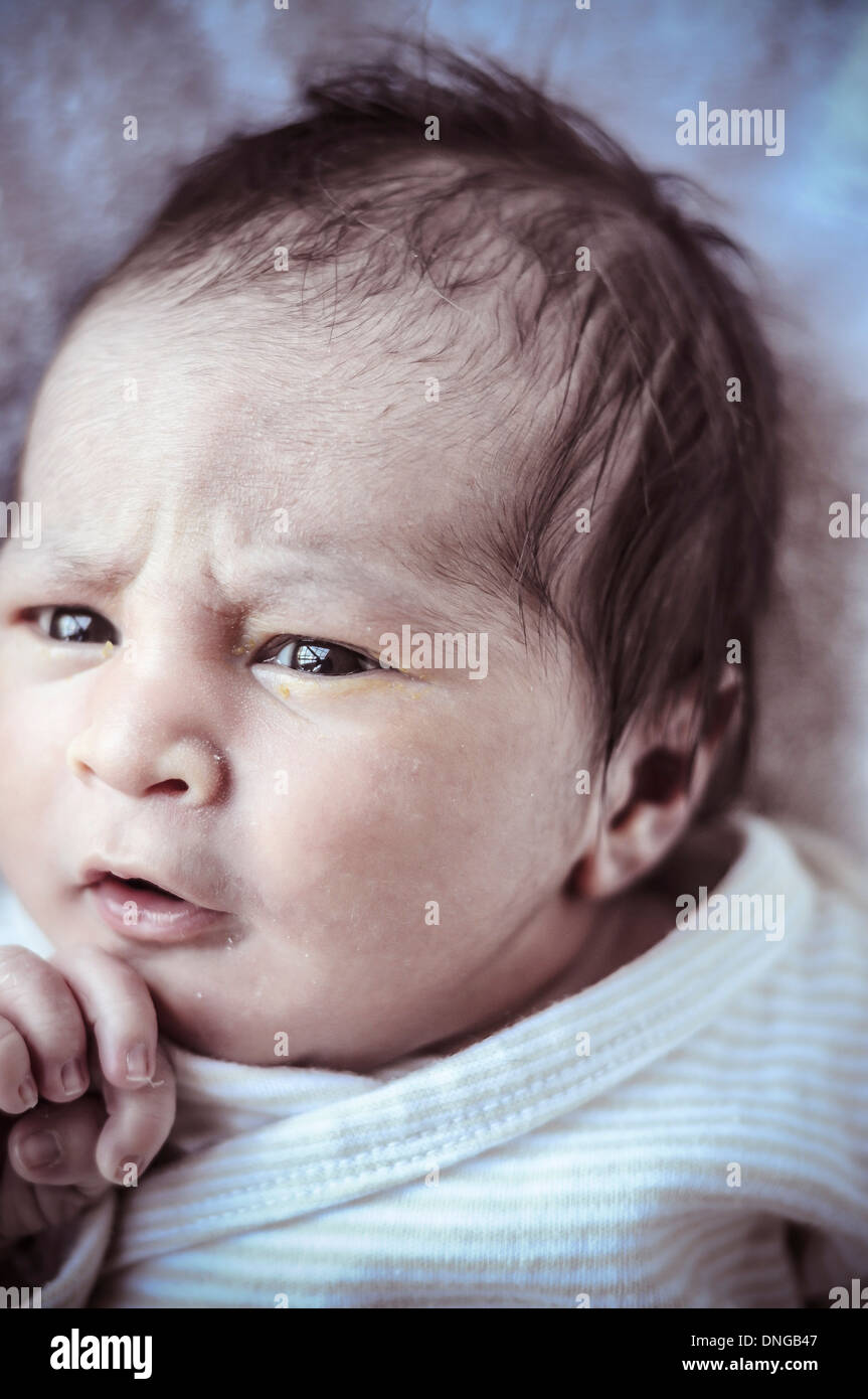 new born baby curled up sleeping on a blanket, multiple expressions ...