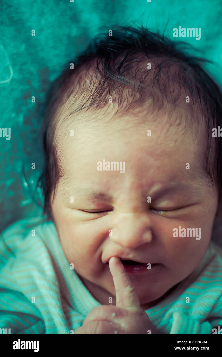 Newborn peacefully sleeping, picture of a baby curled up sleeping on a ...