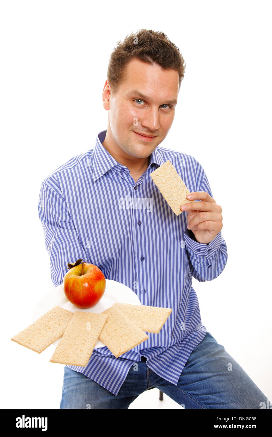 Positive man eating healthy in her diet, having a crispbread and apple ...