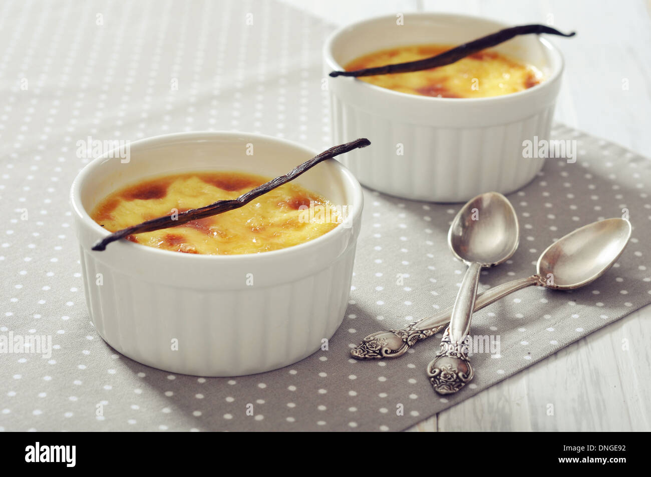 The creme brulee in ceramic baking mold with vanilla pod on wooden ...