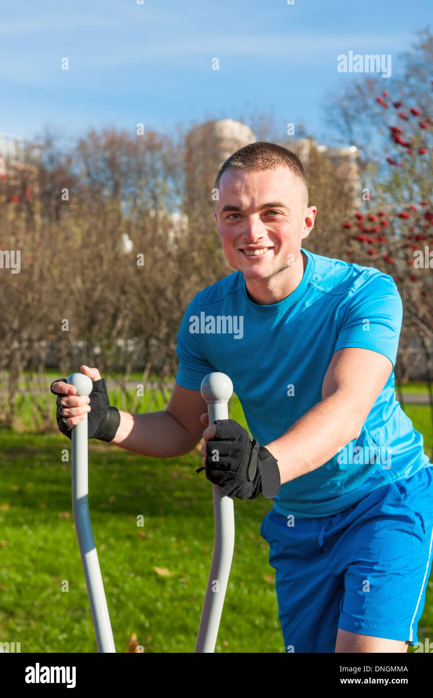 Young handsome man working on running machine in the park Stock Photo ...