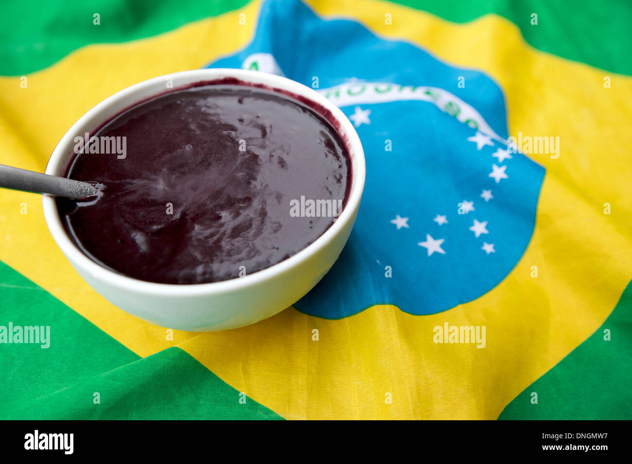 Bowl of fresh frozen acai açaí jussara with spoon on Brazilian flag ...