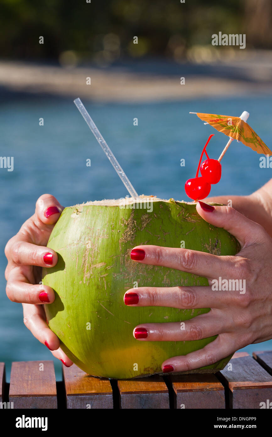 coconut drink served in a green coconut with rum and juices served on ...